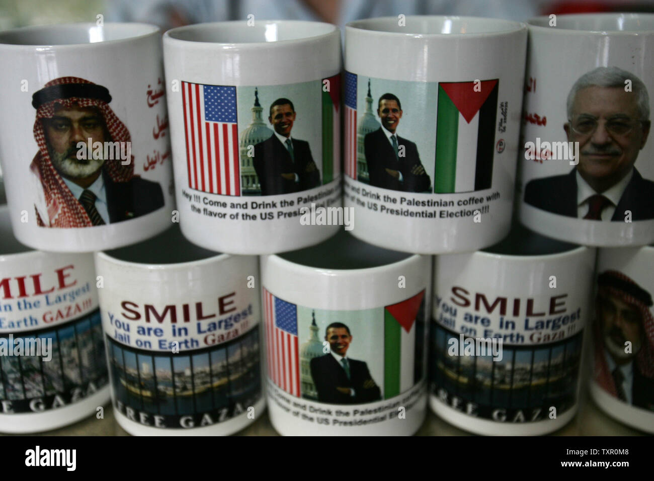 A Palestinian shop owner displays mugs for sale with portraits of US ...