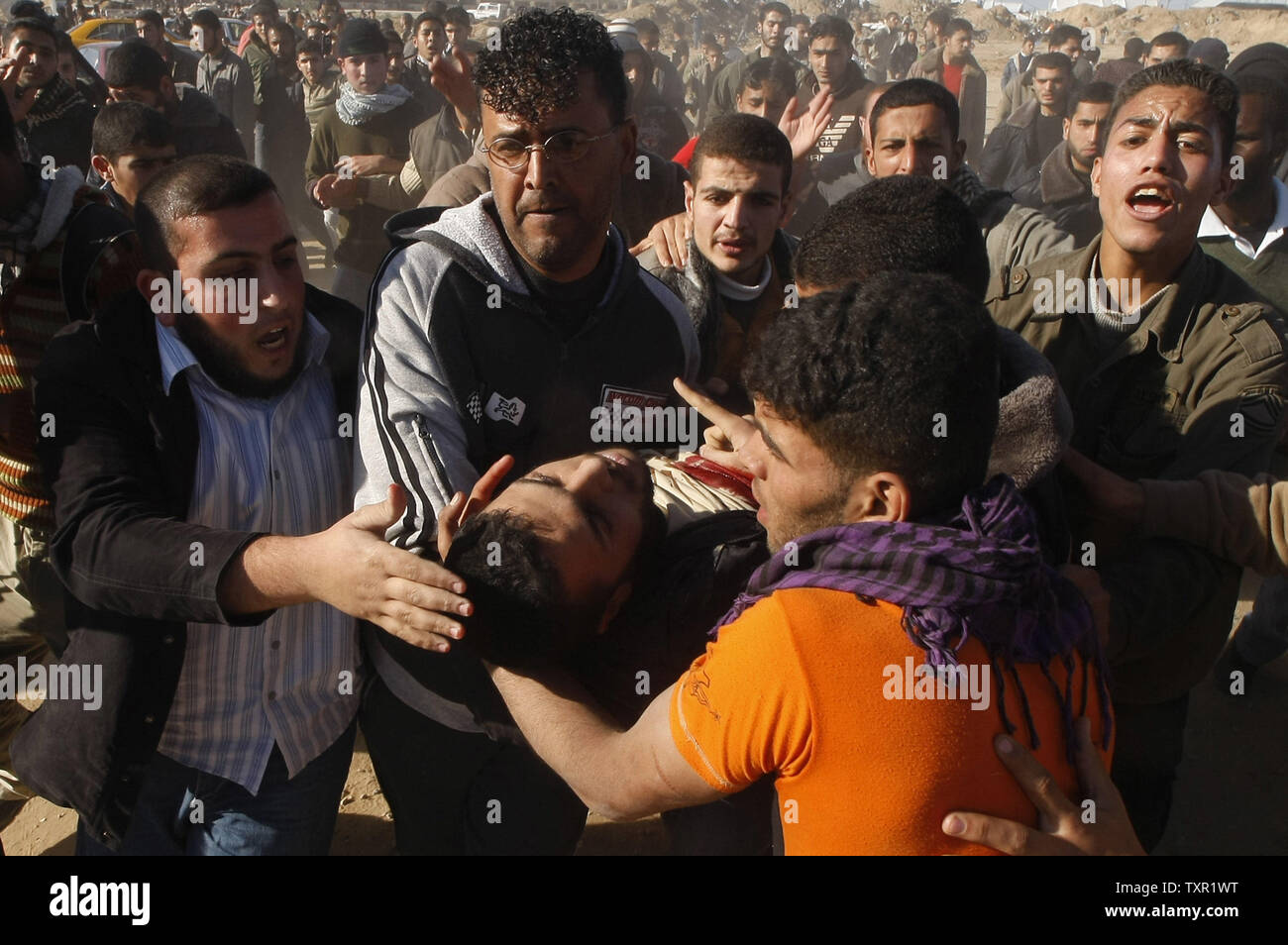 A wounded Palestinians is carried away during during a clash between ...