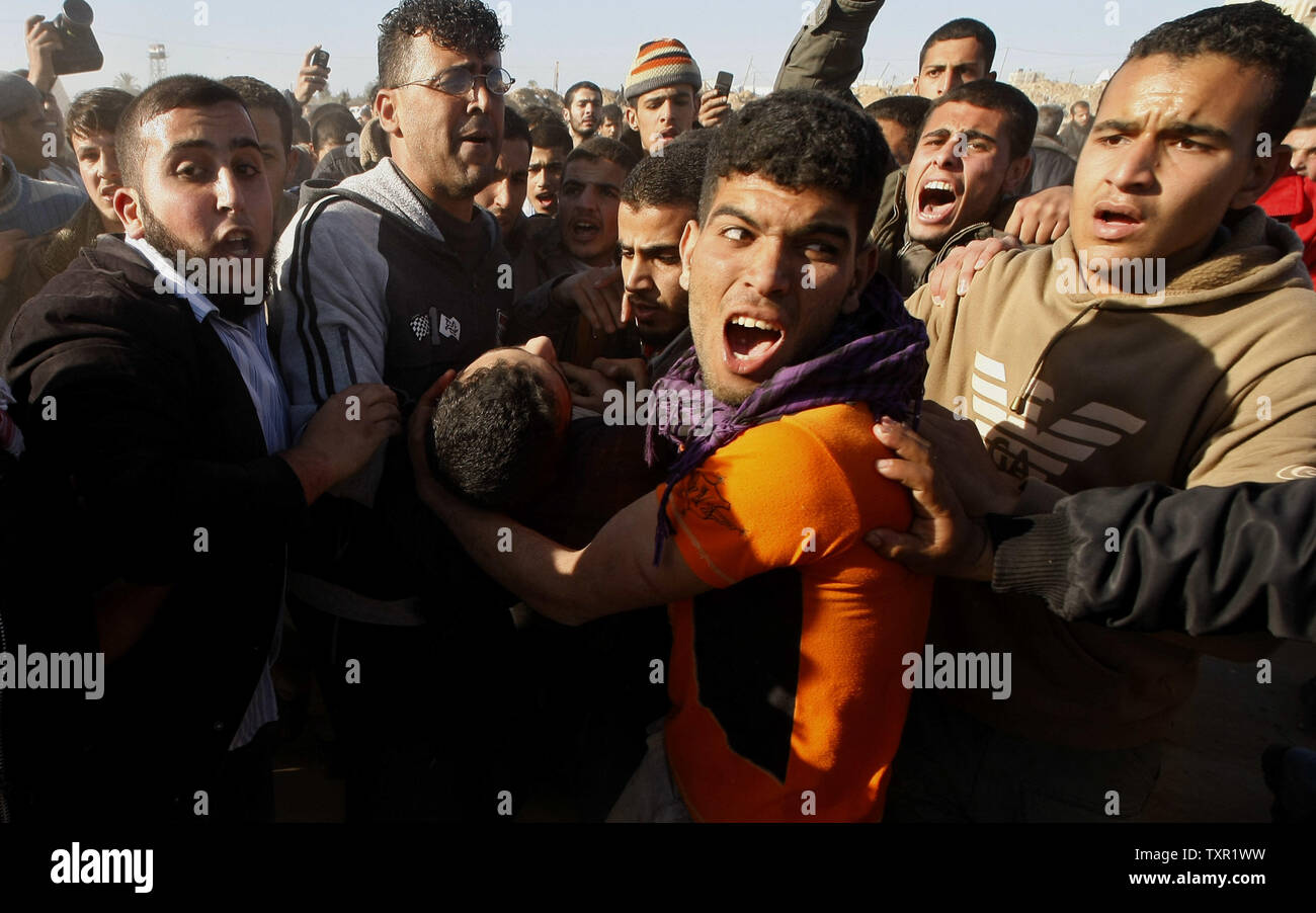 A wounded Palestinians is carried away during during a clash between ...