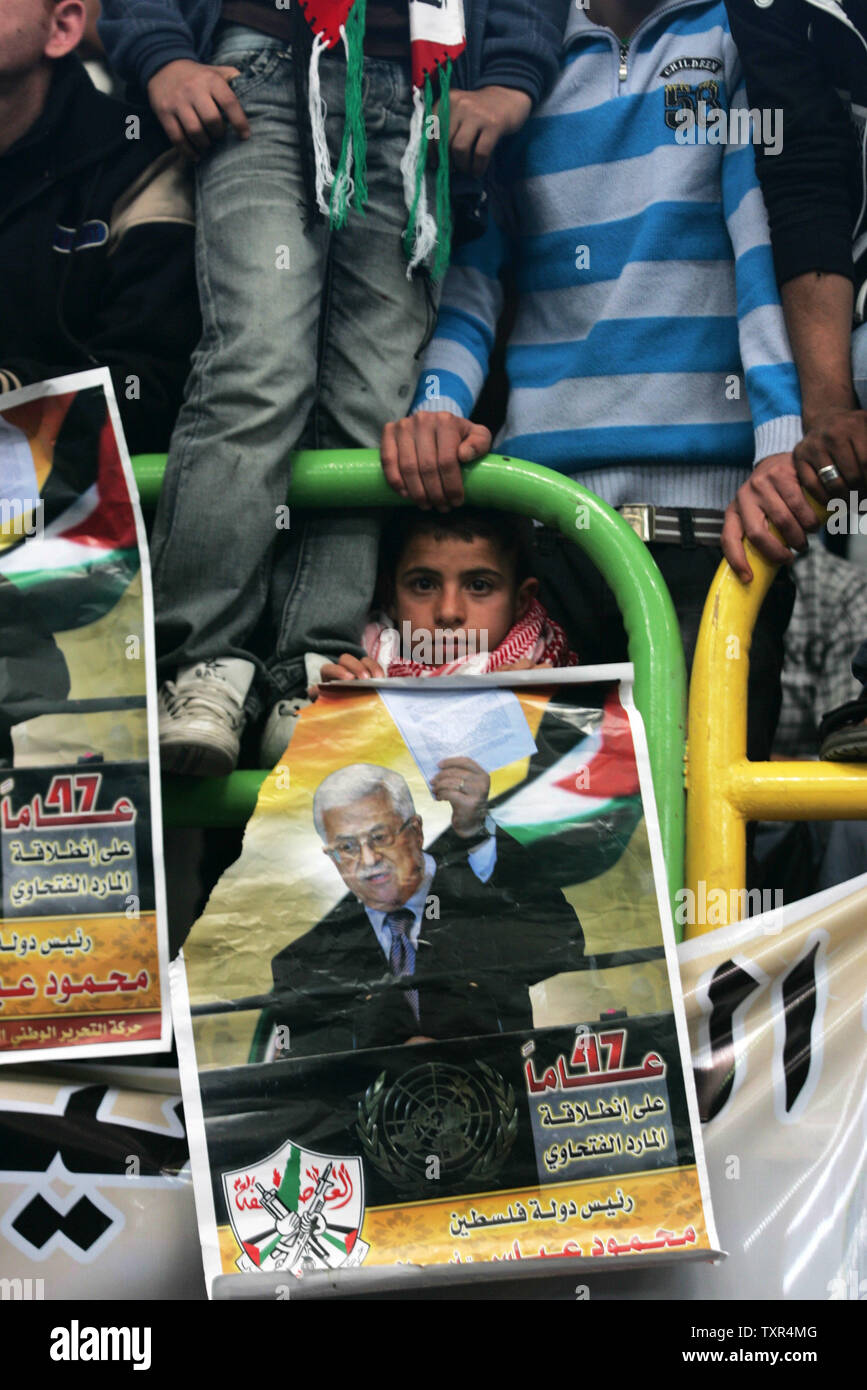 A Palestinian boy hold picture of Palestinian president Mahmoud Abass ...