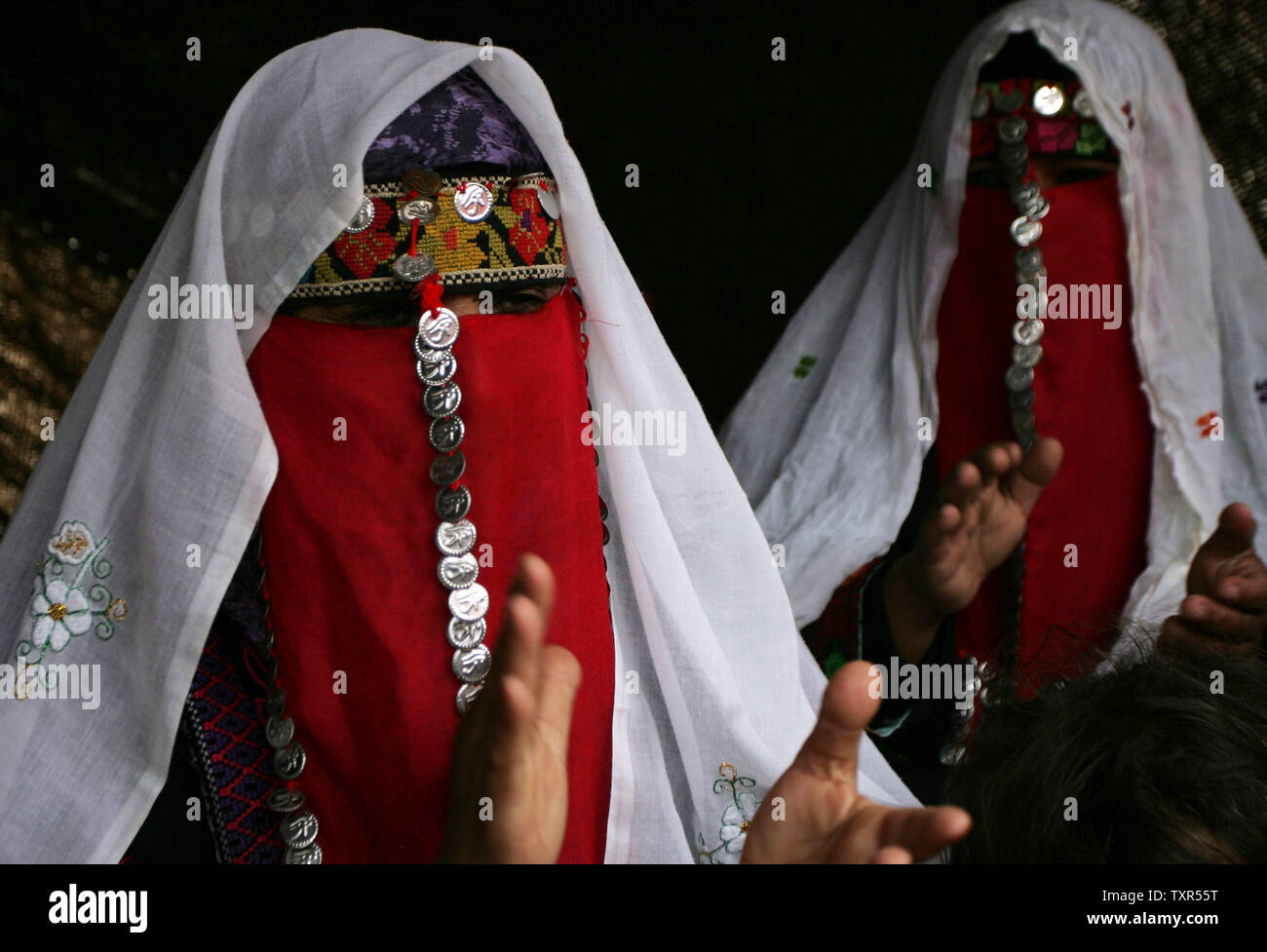 Palestinian women wearing traditional Arabic headdress (Burqa) attend a ...