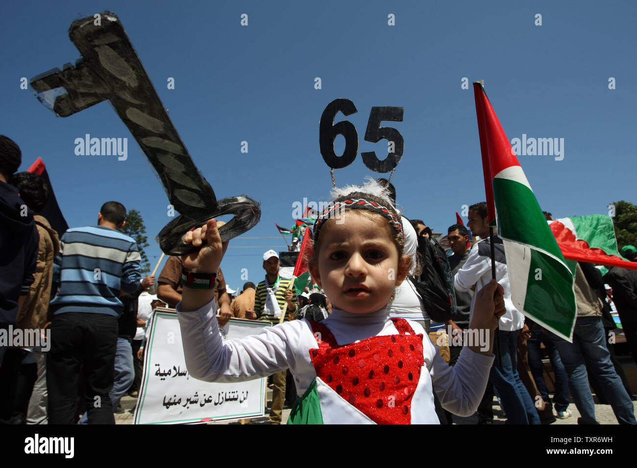 A Palestinian girl holds a replica of a house key, representing the ...