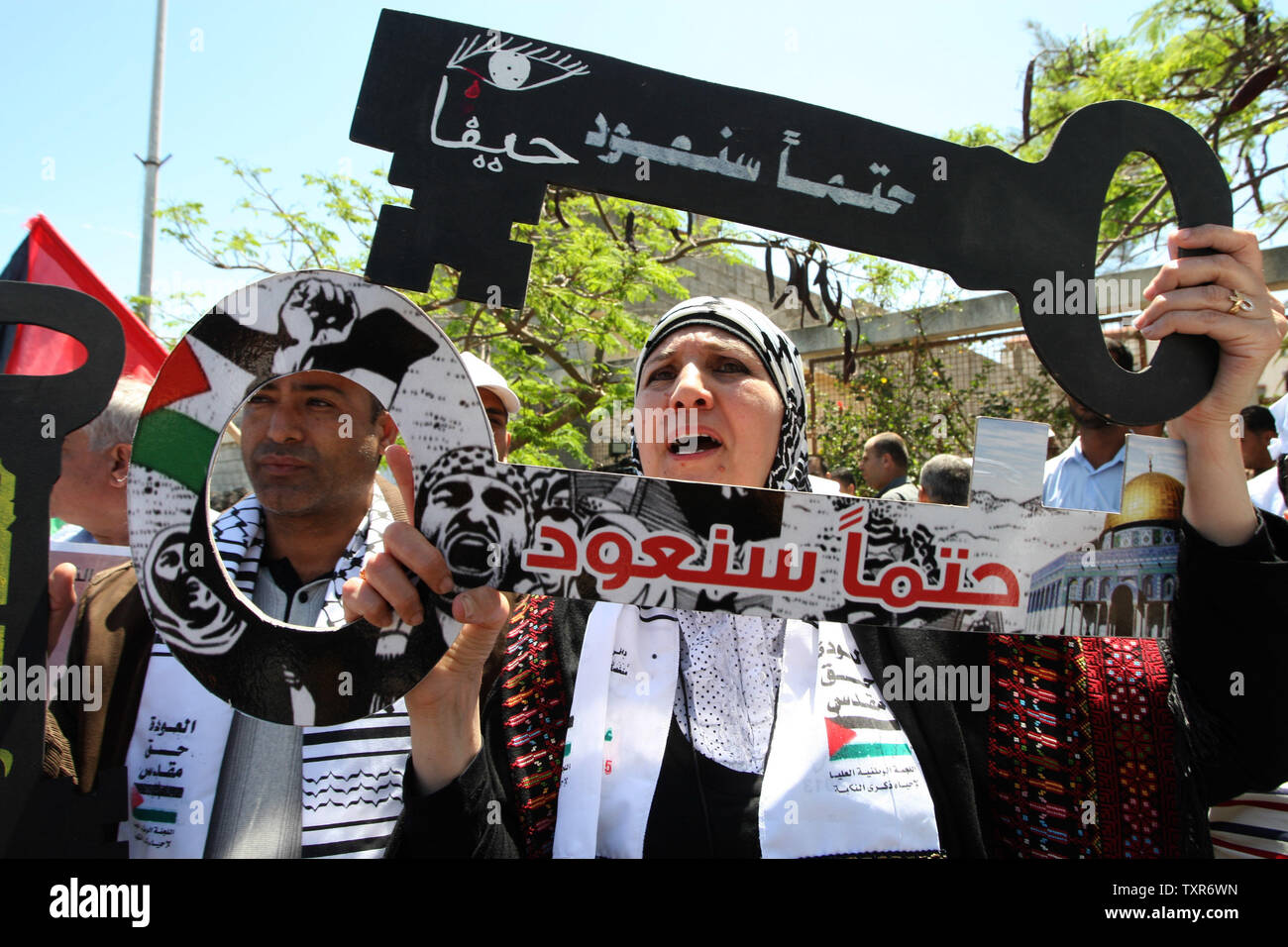 A Palestinian woman holds replicas of house keys, representing the ...