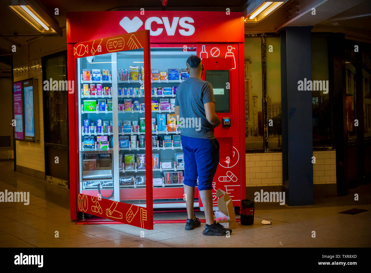 A worker adjusts a CVS branded vending machine selling assorted ...