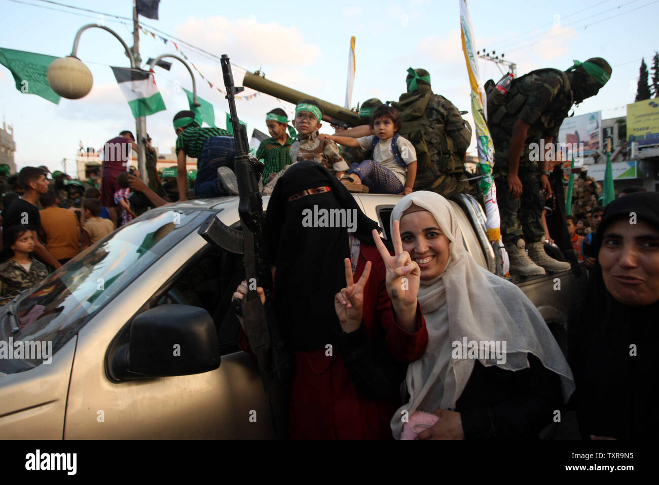Palestinian women take pictures, while militants of the Ezzedine al ...
