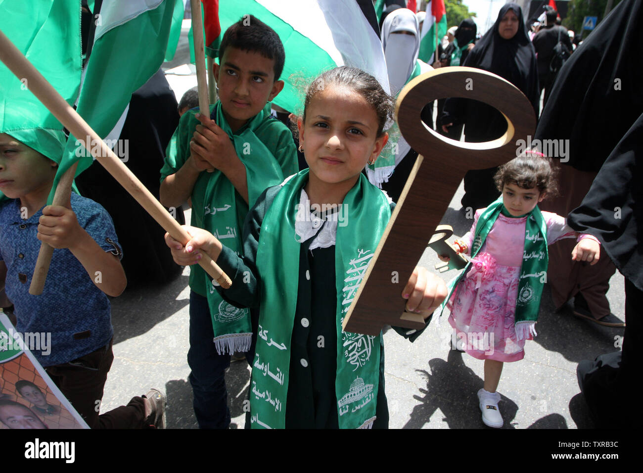 Palestinian children hold big symbolic keys during a rally to mark the ...