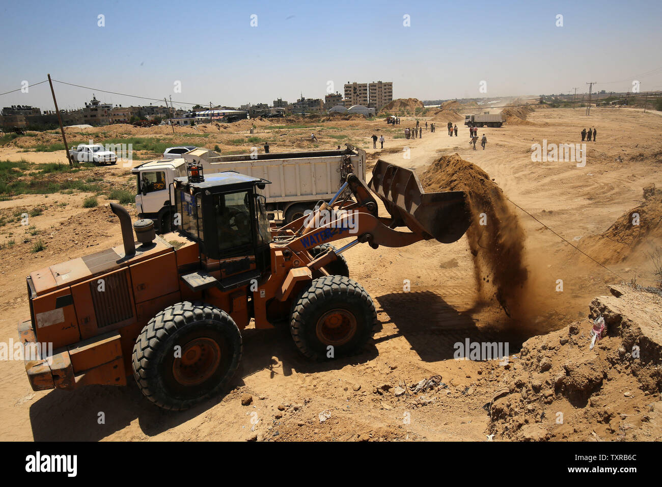 Palestinian bulldozers clear an area as Hamas begins creating a large ...