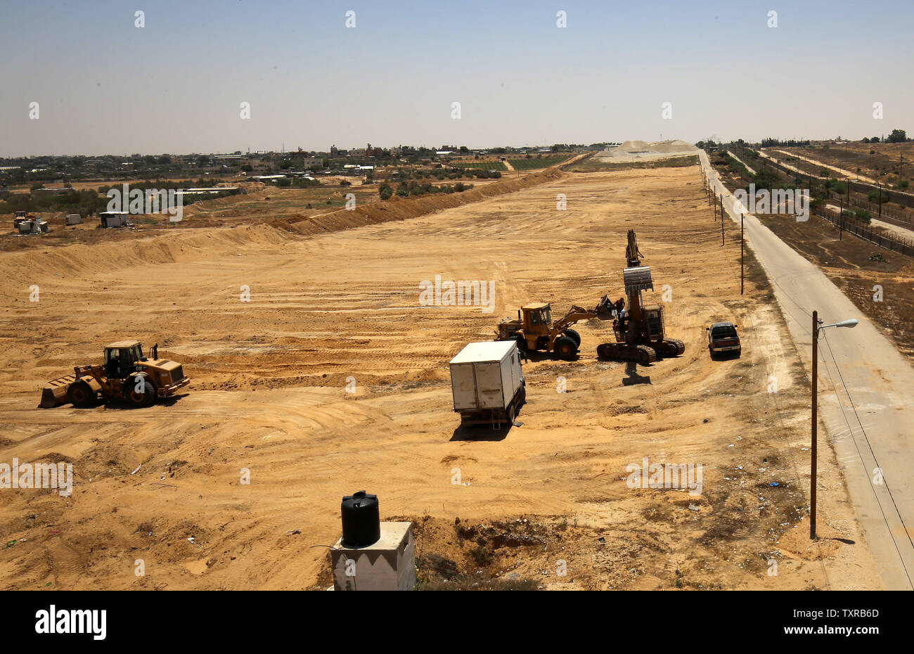 Palestinian bulldozers clear an area as Hamas begins creating a large ...