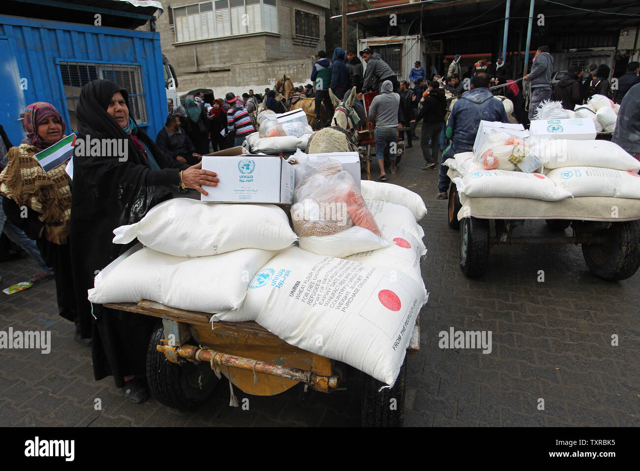 Palestinian refugees collect aid parcels at a United Nations food ...