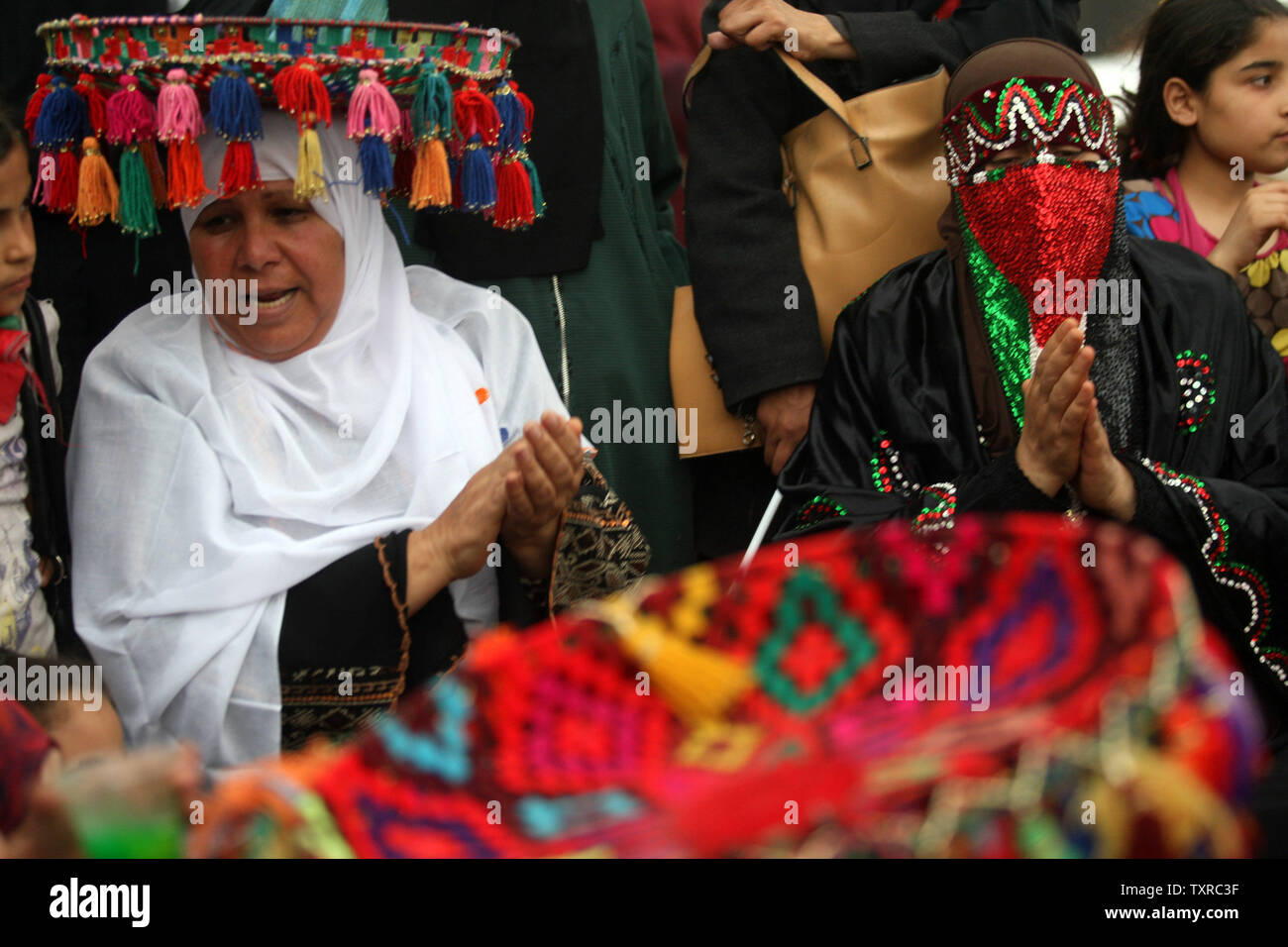 Palestinian women are seen dressed in traditional outfits during a tent ...