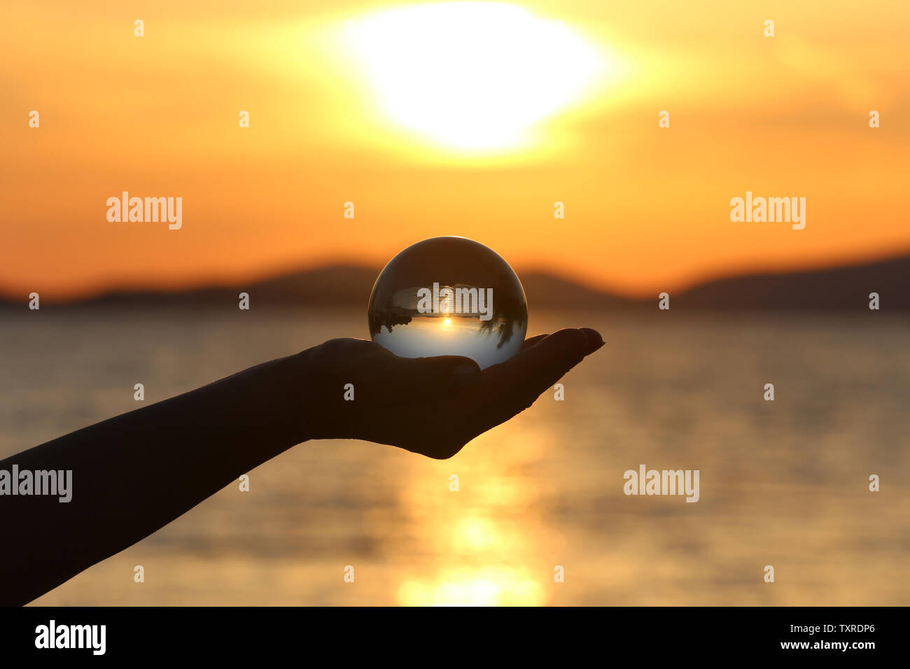 Glass ball reflection of sea sunset Stock Photo - Alamy