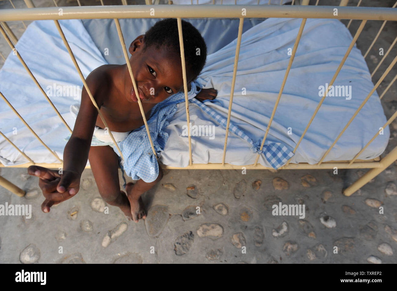 A mentally challenged child sits in a crib at an outdoor children's ...