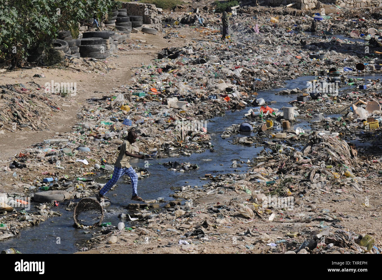 A man crosses a polluted stream in Port-au-Prince, Haiti on January 27 ...