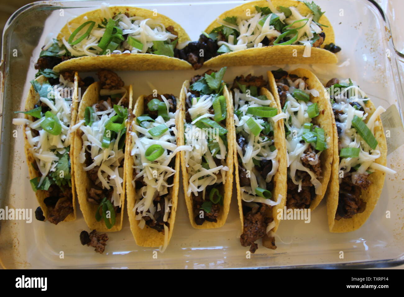 three beef tacos with cheese, lettuce and tomatoes Stock Photo - Alamy