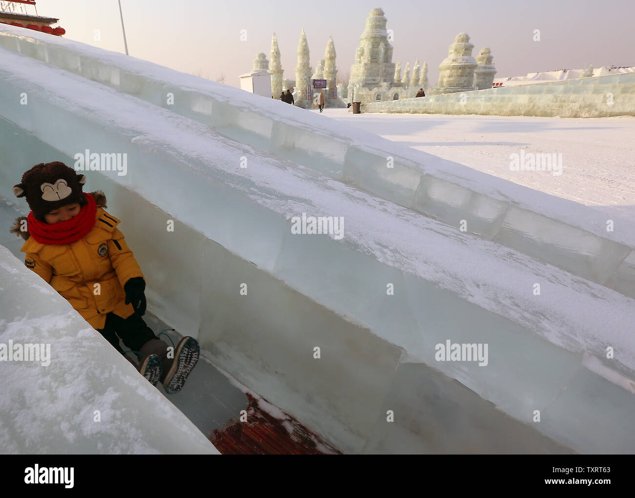 A Chinese boy slides down an ice slide at the 33rd Harbin International ...
