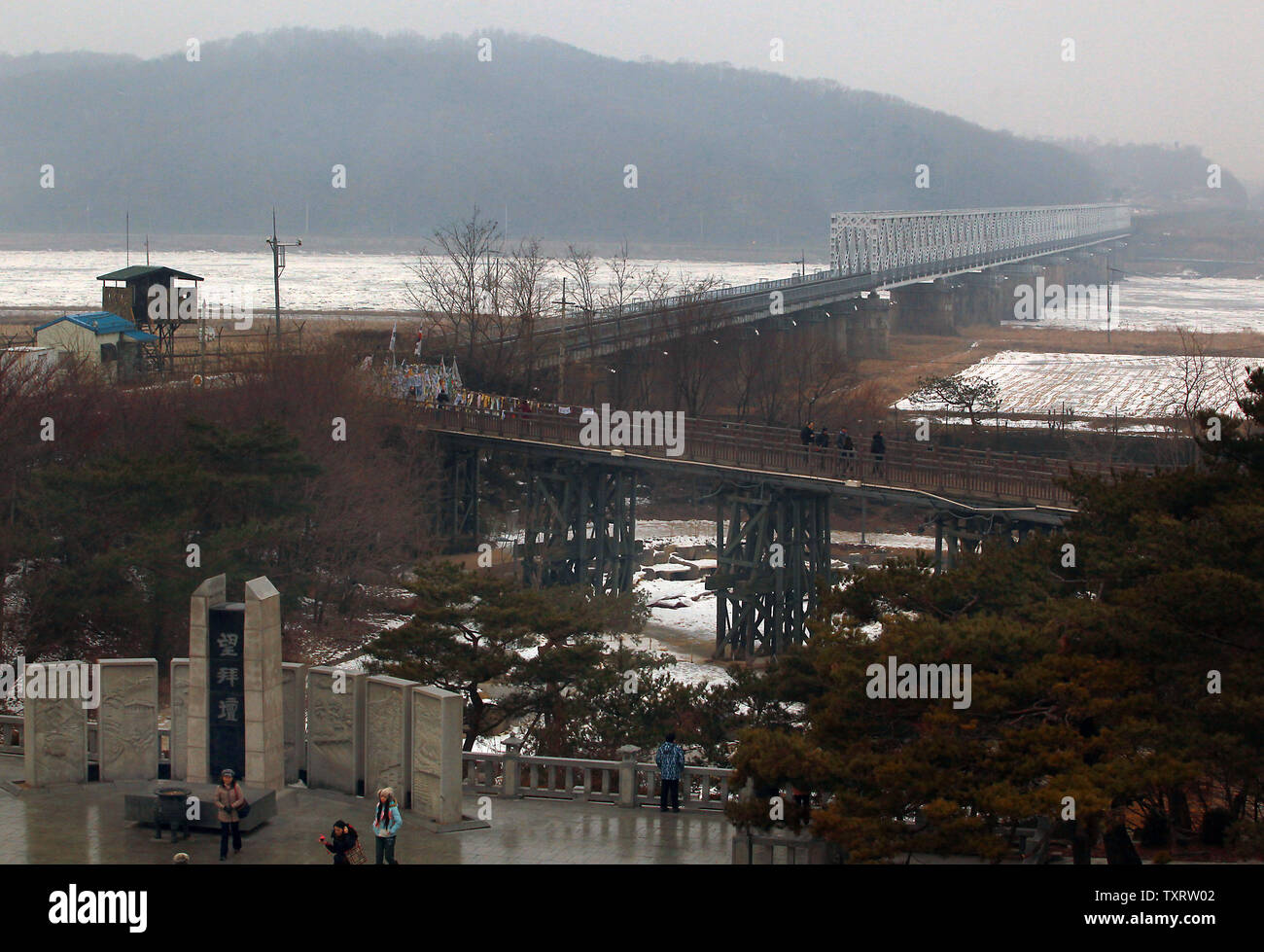 Tourists walk across part of the wooden Freedom Bridge, used for the ...