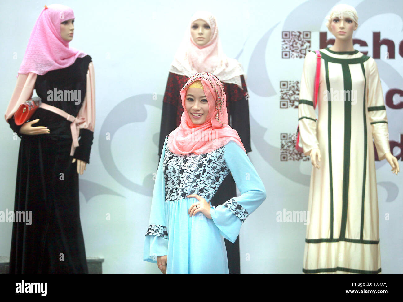 Chinese Muslim women display traditional religious clothing at a booth ...