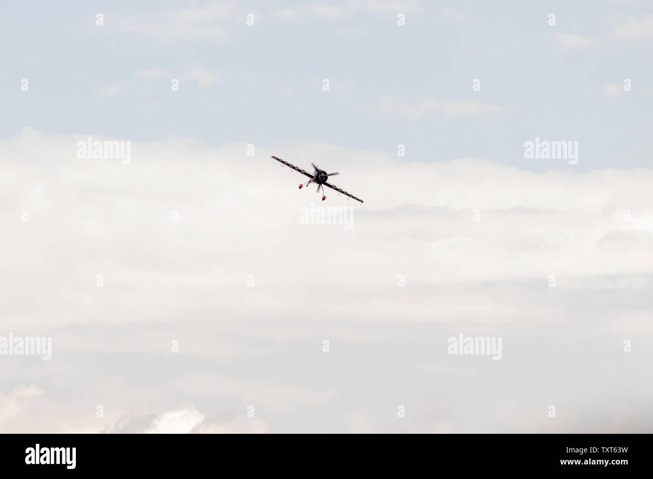 Propeller plane in flight seen from the front with many clouds at an ...