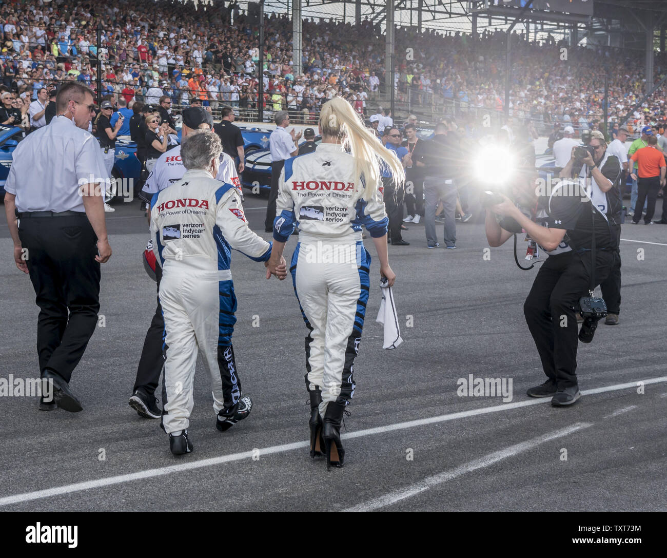 Mario Andretti and Lady Gaga hold hands as they walk to the two seater ...
