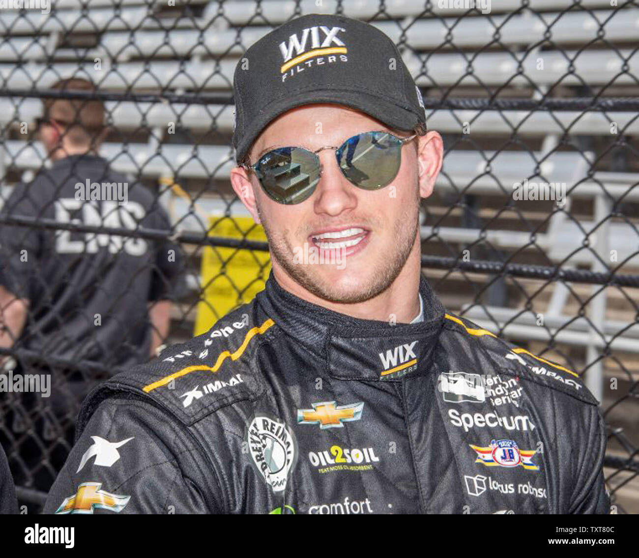 Driver Sage Karam smiles as he walks to his race car during practice ...