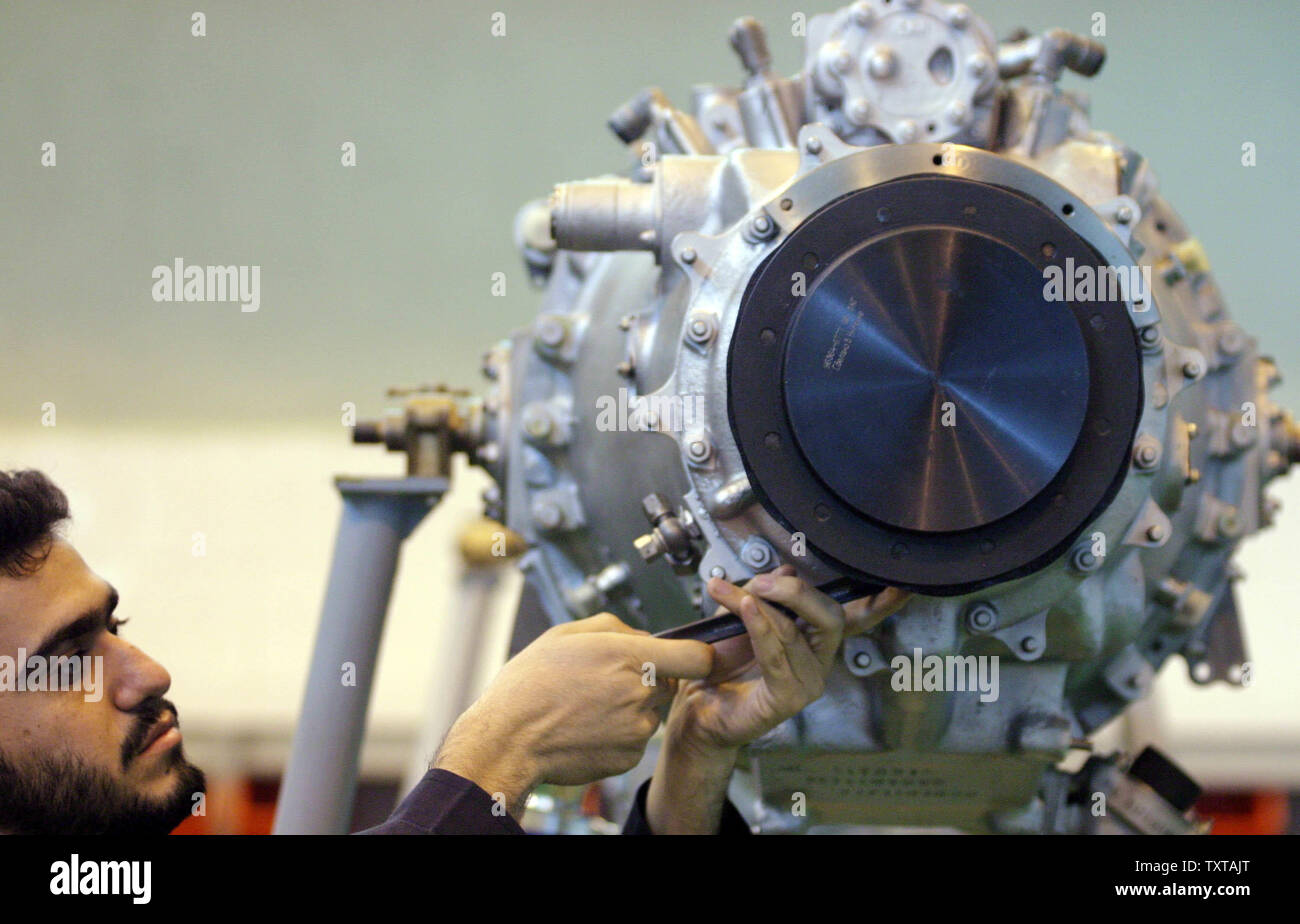 A technician makes adjustments to the first aircraft engine produced in ...