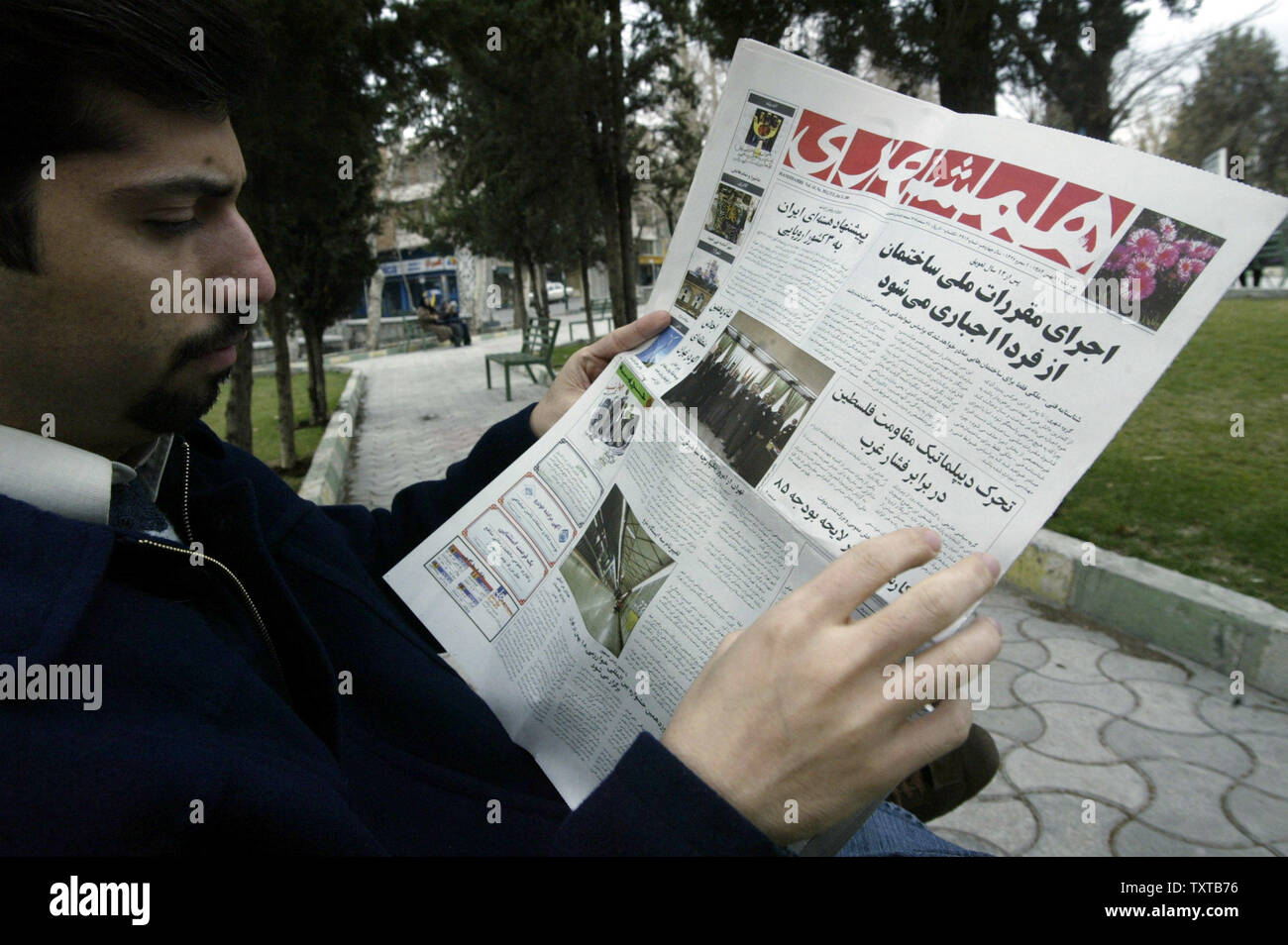 An Iranian caricaturist Hadi Heydari reads the Iranian newspaper ...