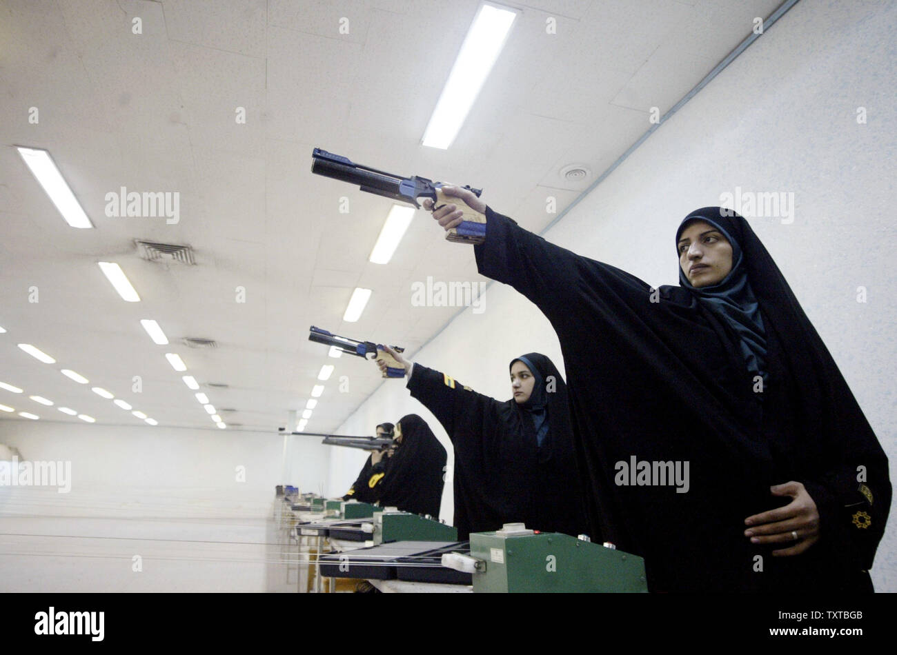 Iranian policewomen fire their pistols during their graduation ceremony ...