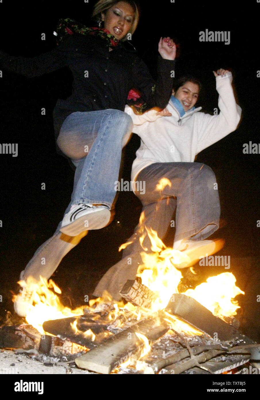 Iranian young women jump over a fire during a ceremony celebrating the ...