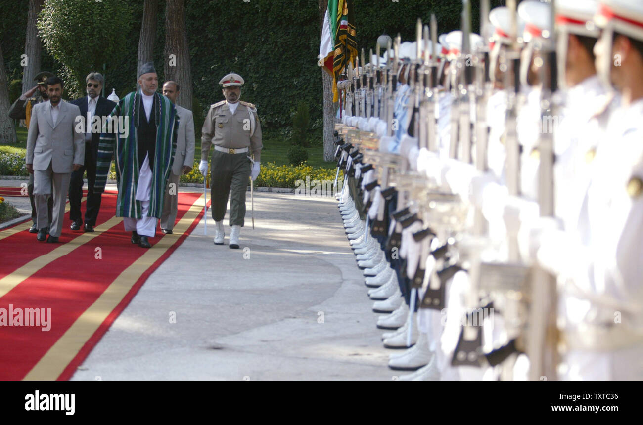 Iran's President Mahmoud Ahmadinejad (wearing a white coat) and ...