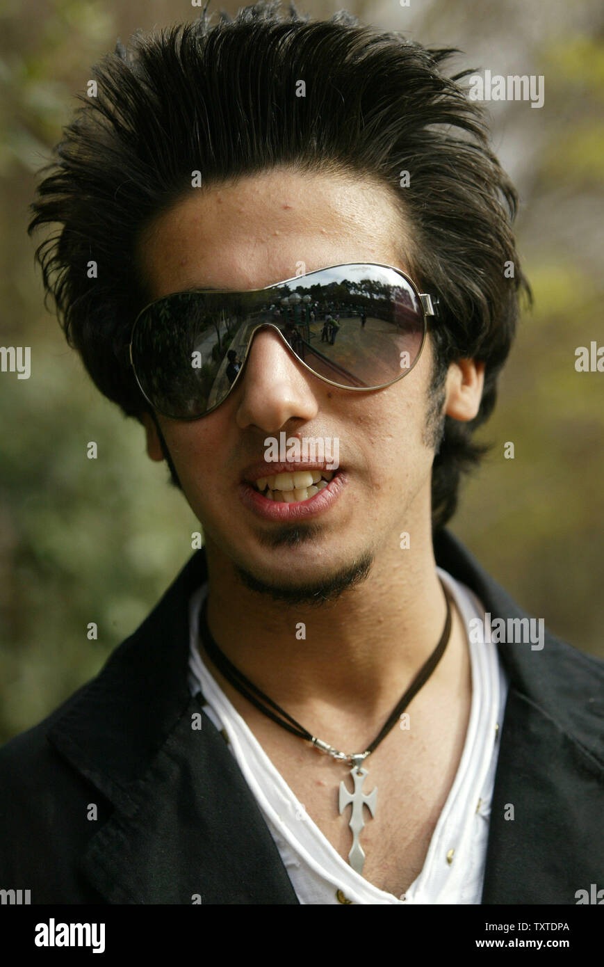 An Iranian man sports a modish look with a cross neckless in Saie park ...