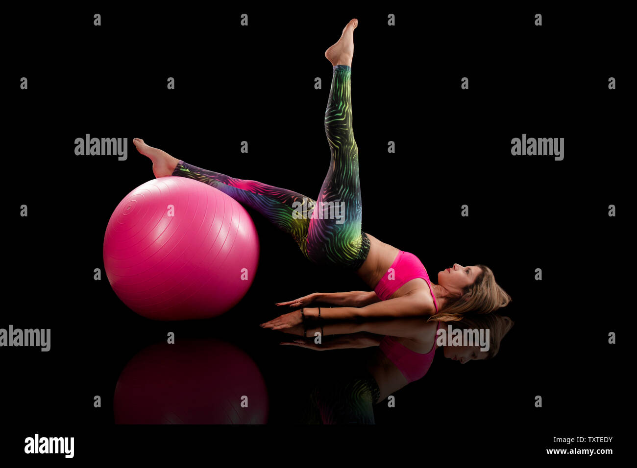 fitness girl exercise with ball on a black background Stock Photo - Alamy