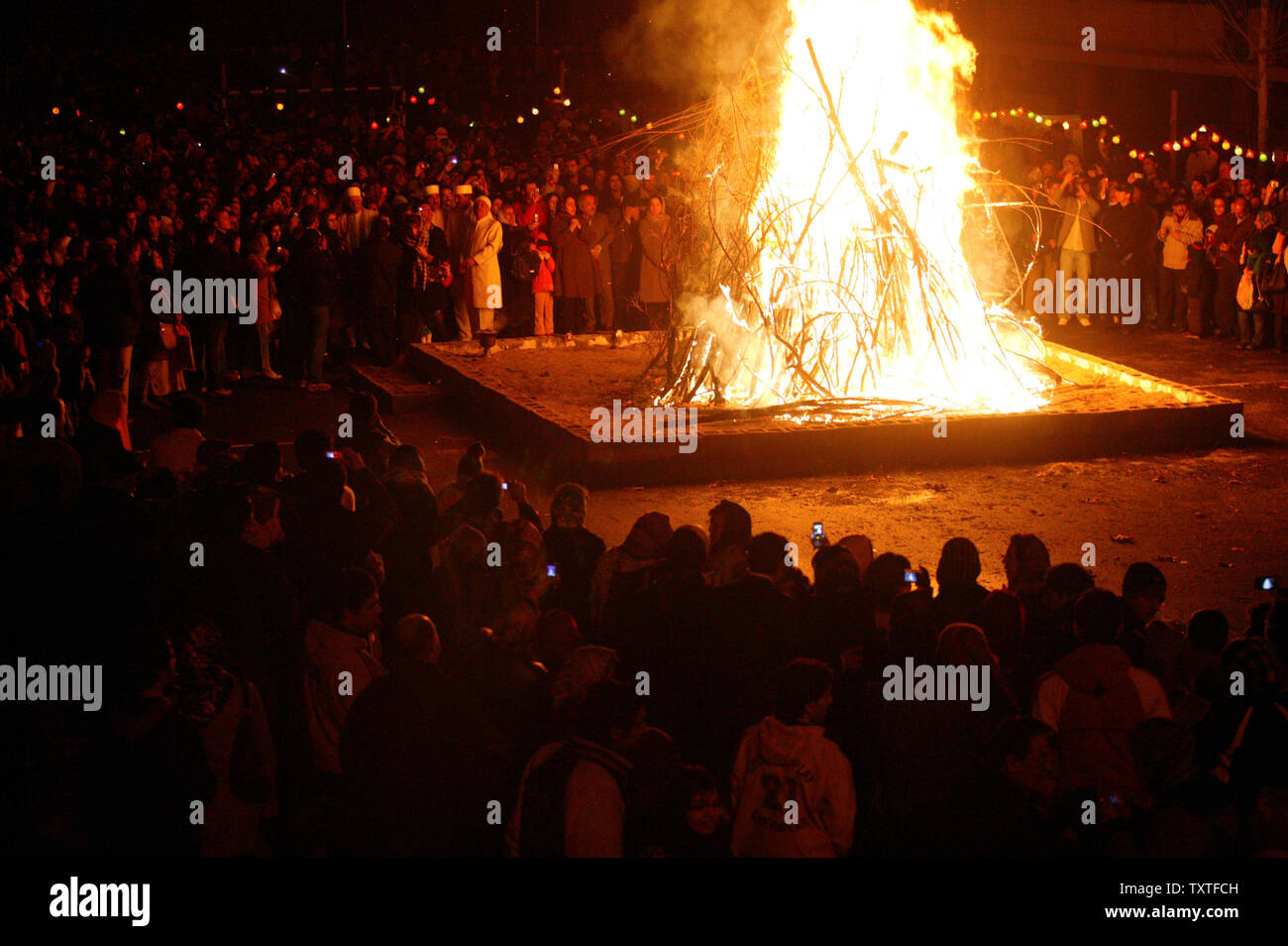 Iranian Zoroastrians make a human chain around a fire during ...
