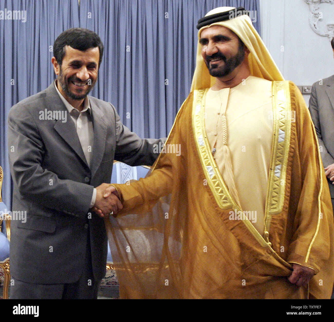 Iran's President Mahmoud Ahmadinejad (L) shakes hand with UAE Prime ...