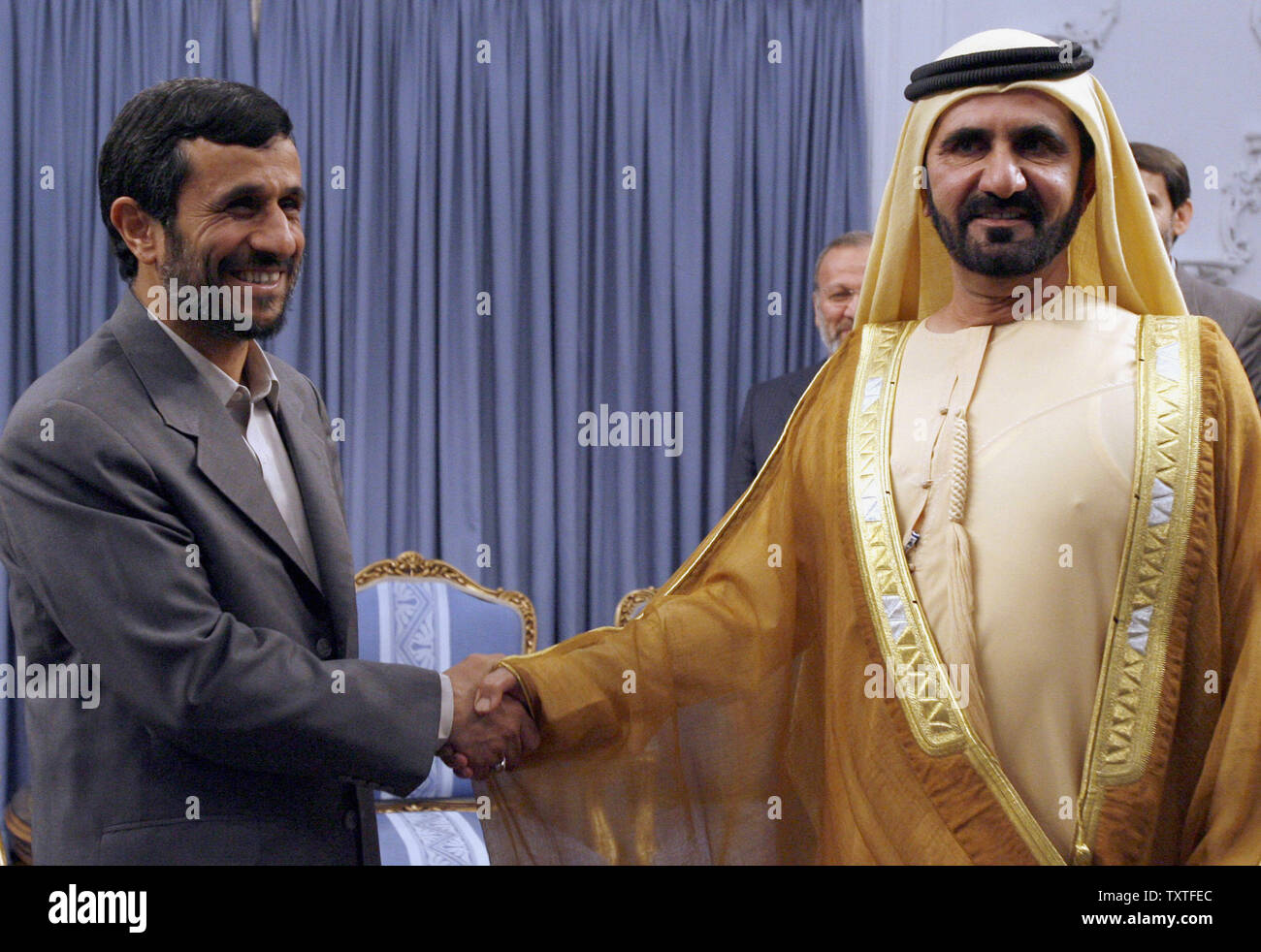 Iran's President Mahmoud Ahmadinejad (L) shakes hand with UAE Prime ...
