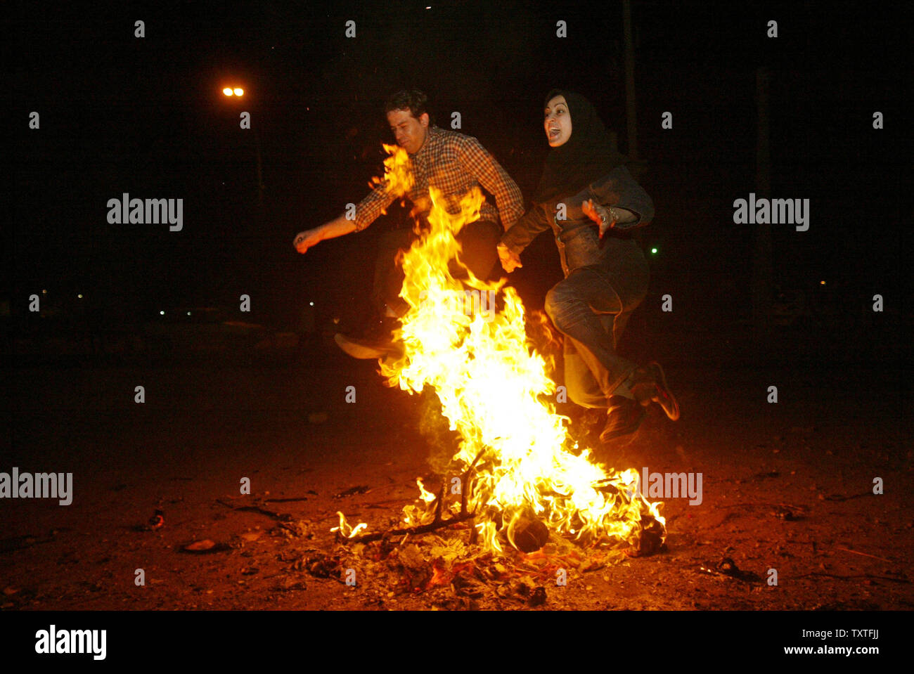 Iranian Reza Darzi and his wife Masoumeh, jump above fire during a ...