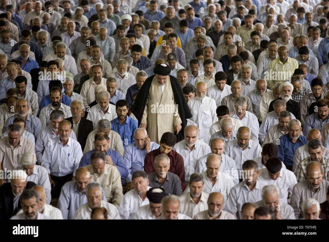 An Iranian clergyman (C) prays among other worshippers during Friday ...