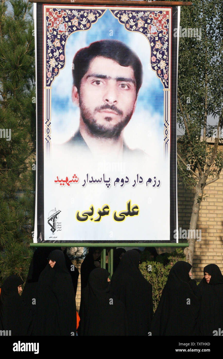 Iranian women standing under the picture of Ali Arabi in a funeral ...
