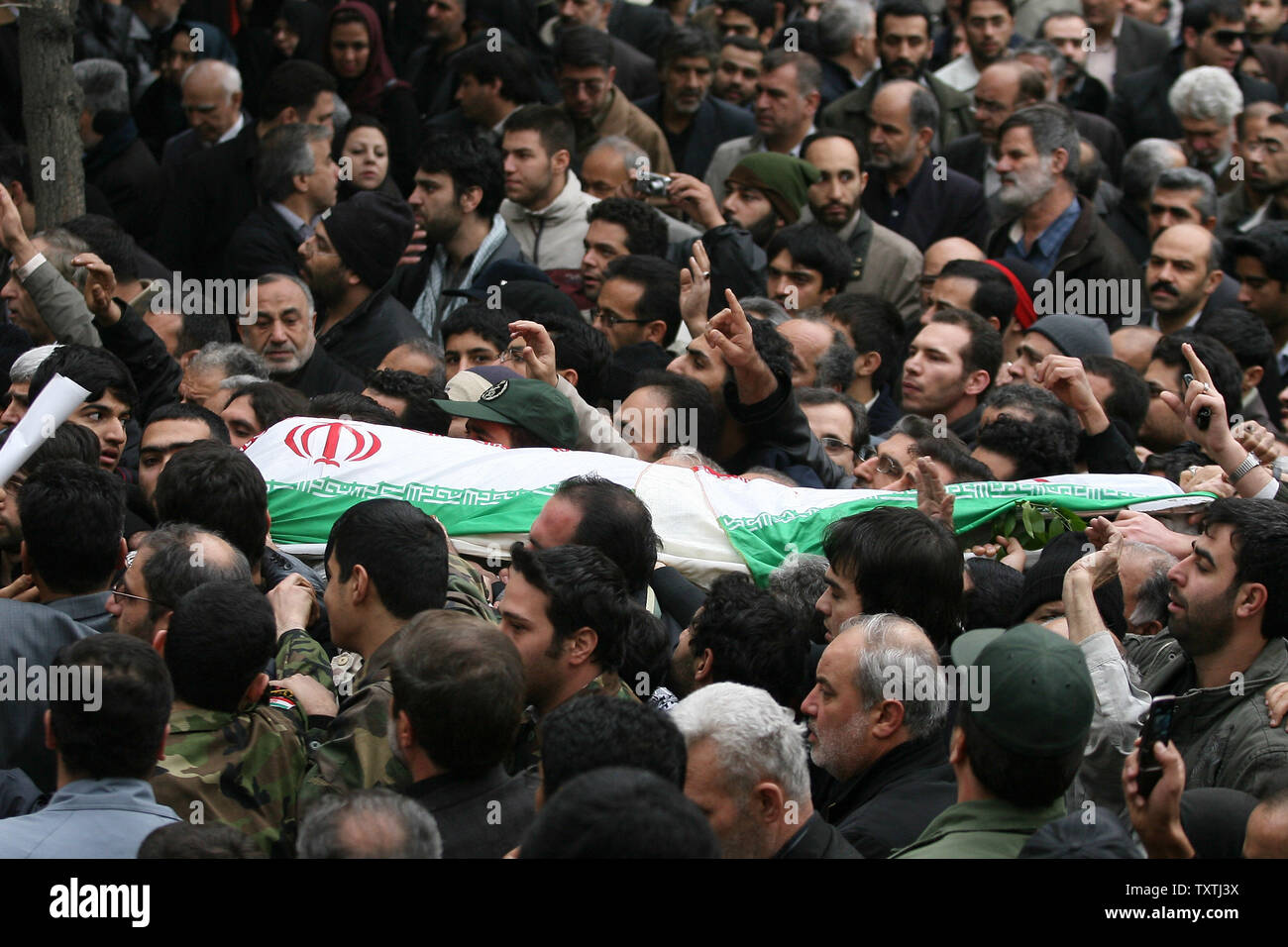 Iranian mourners carry the flag-covered body of professor Massoud Ali ...