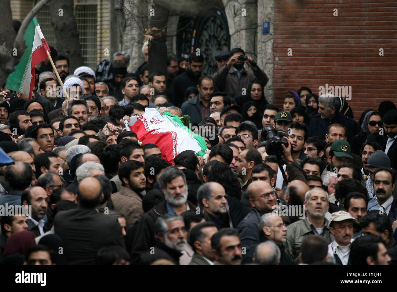 Iranian mourners carry the flag-covered body of professor Massoud Ali ...