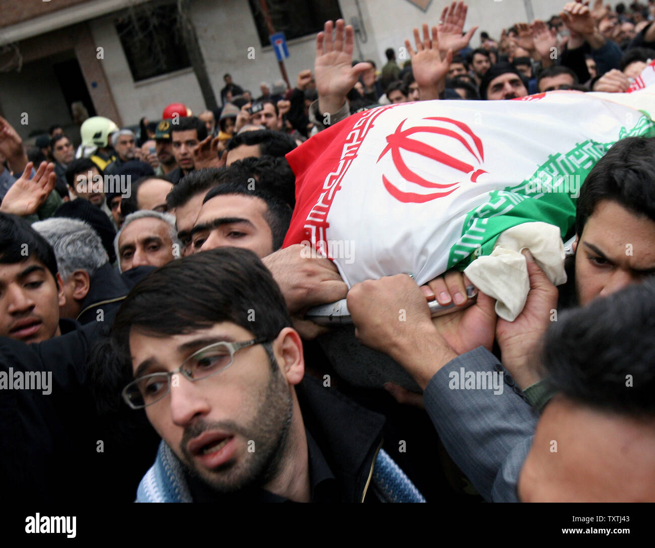 Iranian mourners carry the flag-covered body of professor Massoud Ali ...