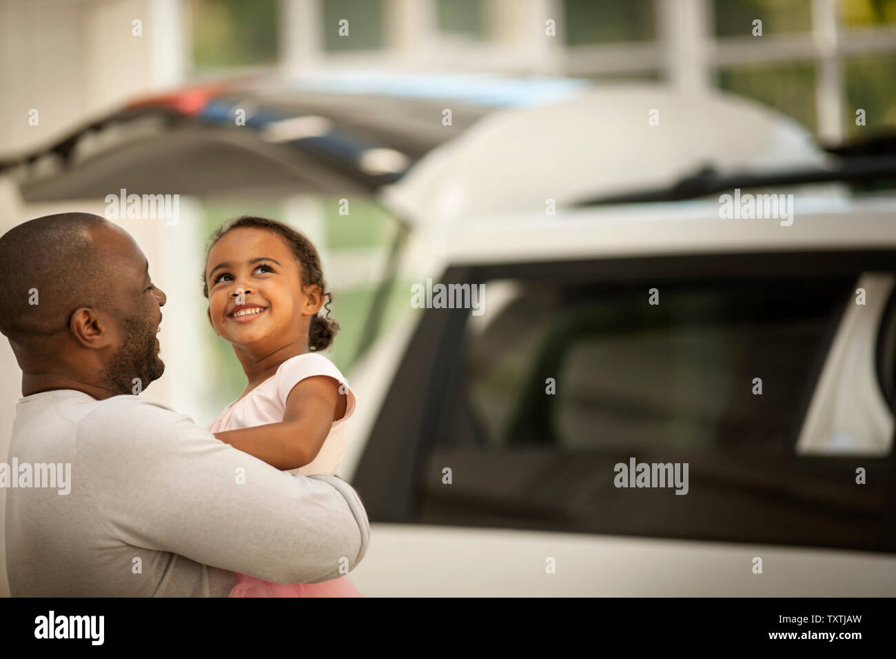 Happy father carrying his smiling daughter to the car Stock Photo - Alamy