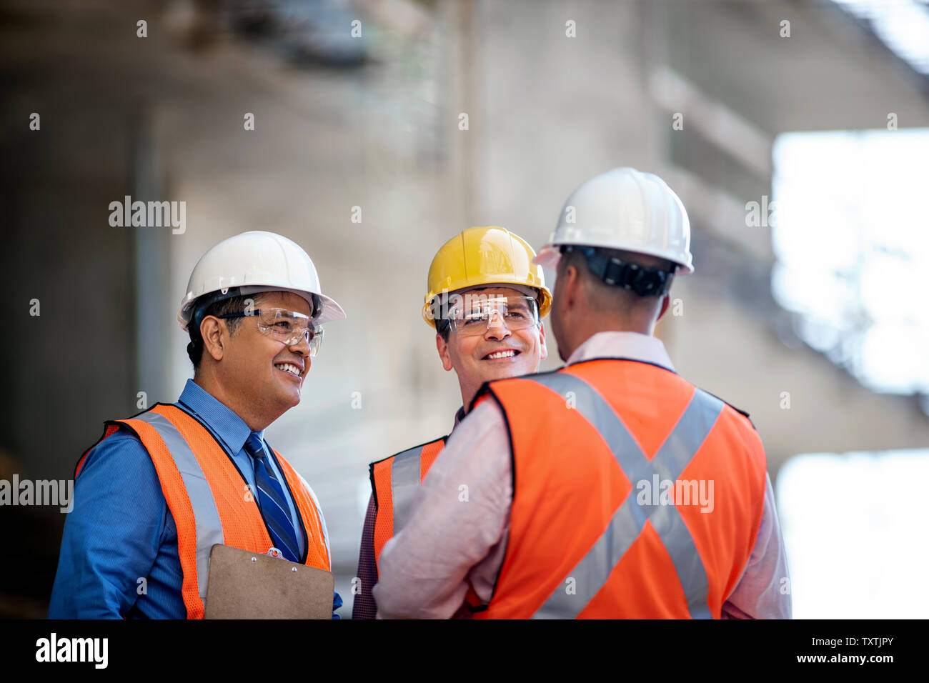 Workers at construction site discuss progress Stock Photo - Alamy