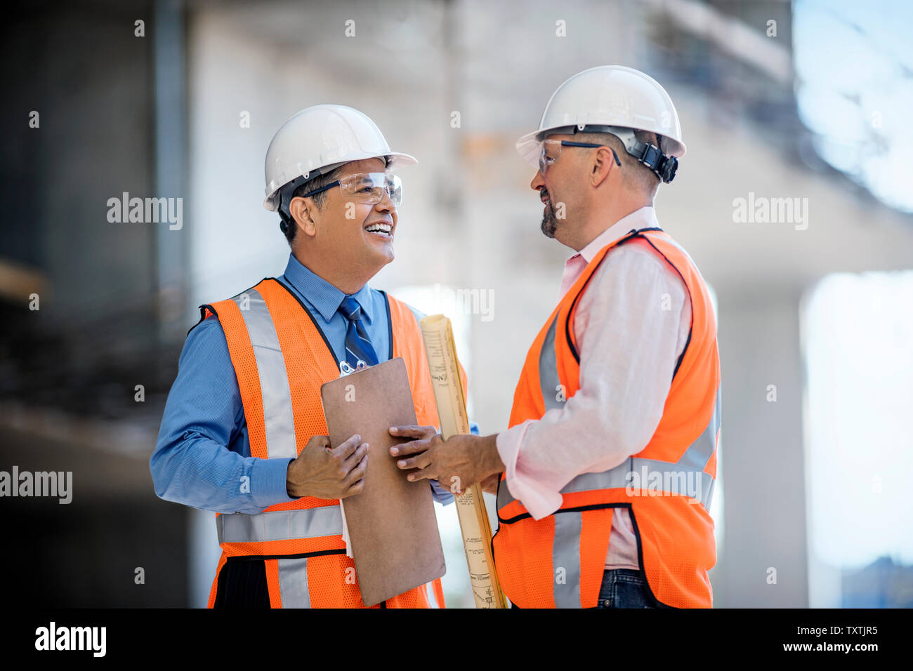 Workers at construction site discuss progress Stock Photo - Alamy