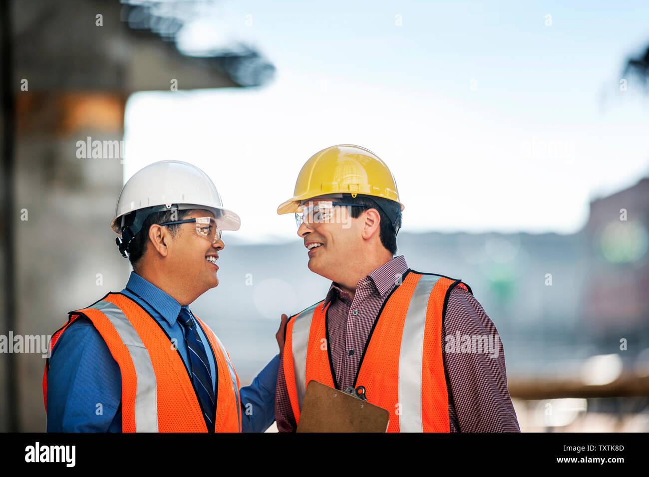 Workers at construction site discuss progress Stock Photo - Alamy