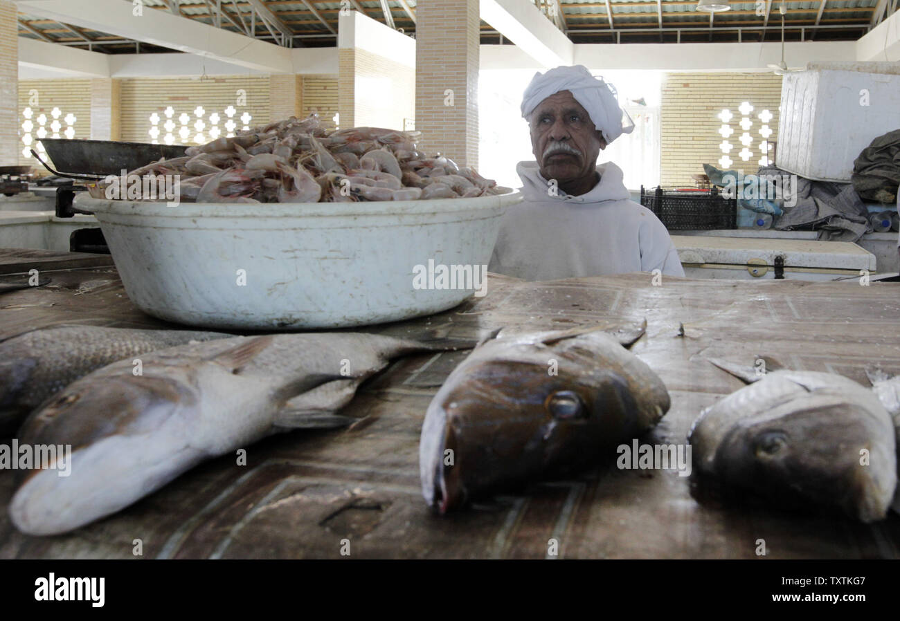 An Iranian vendor sells fish as he wears traditional cloth in Qeshm ...