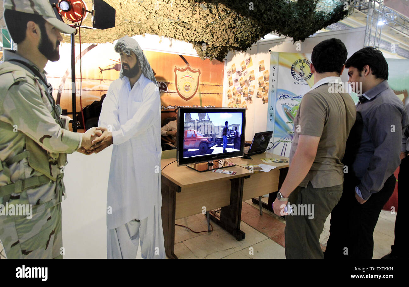 Iranian boys watch a video game during the second International ...