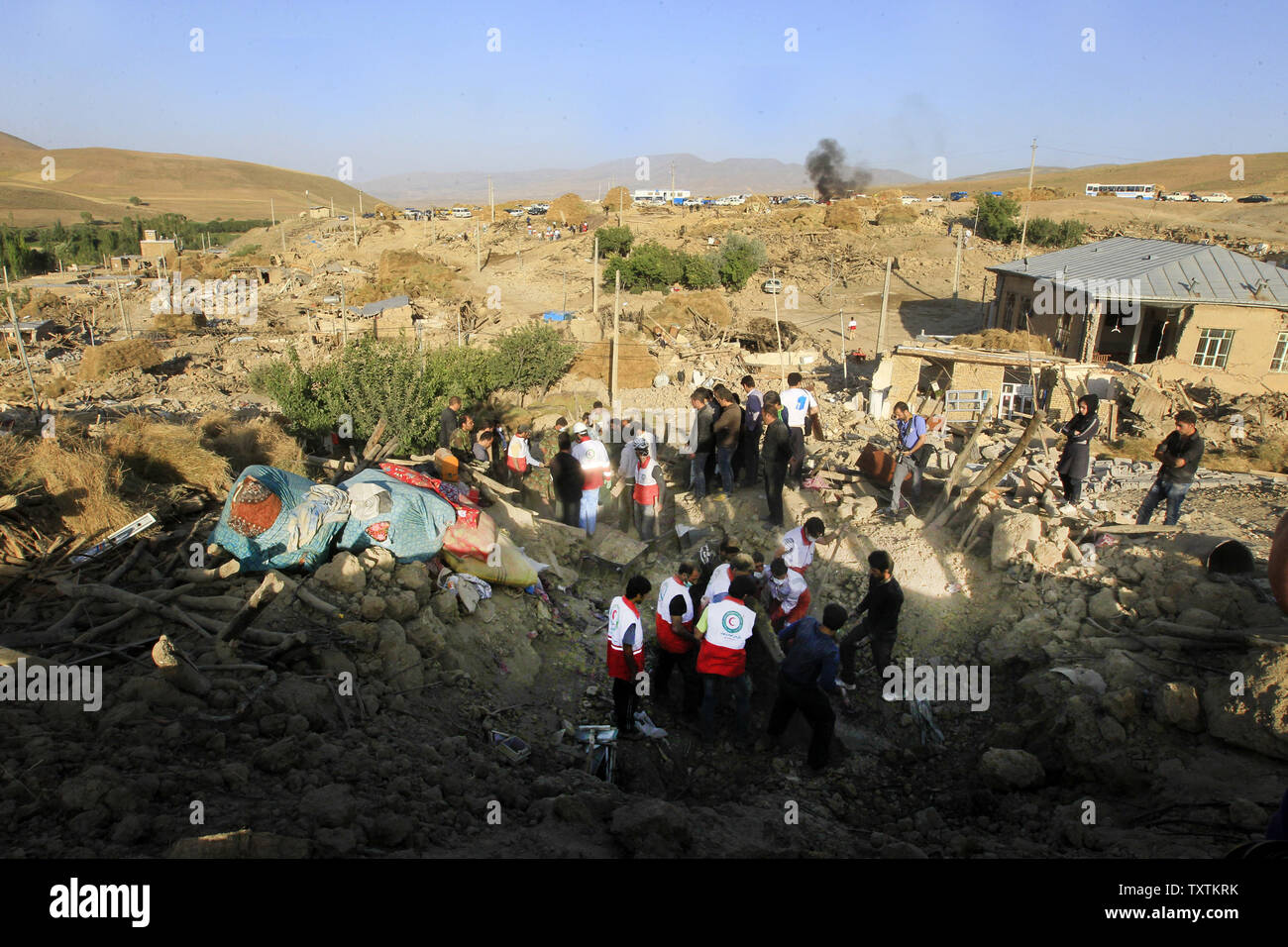 Rescue teams search for victims in the rubble of destroyed buildings in ...