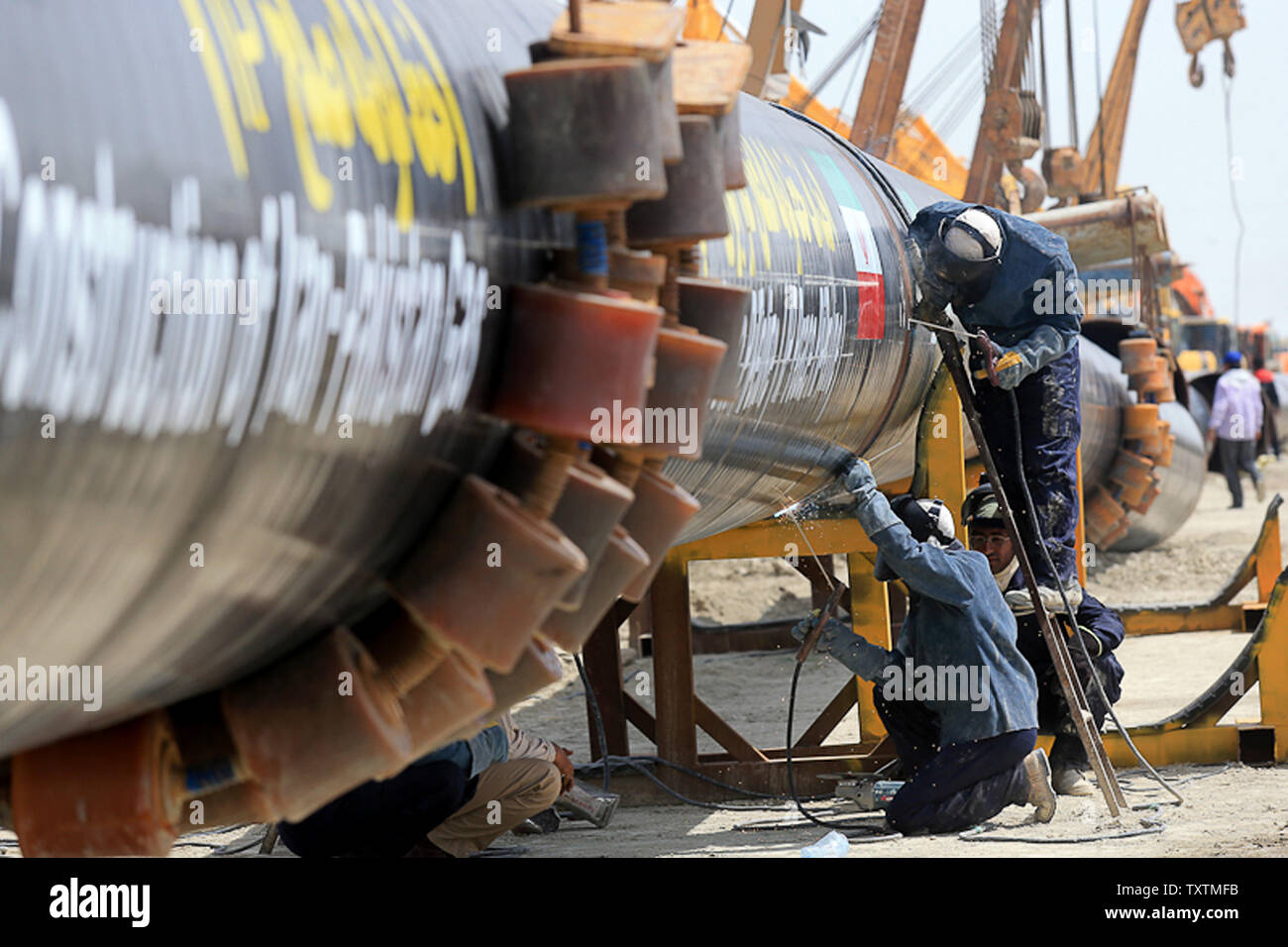 Iranian workers help construct a gas pipeline designed to transfer ...