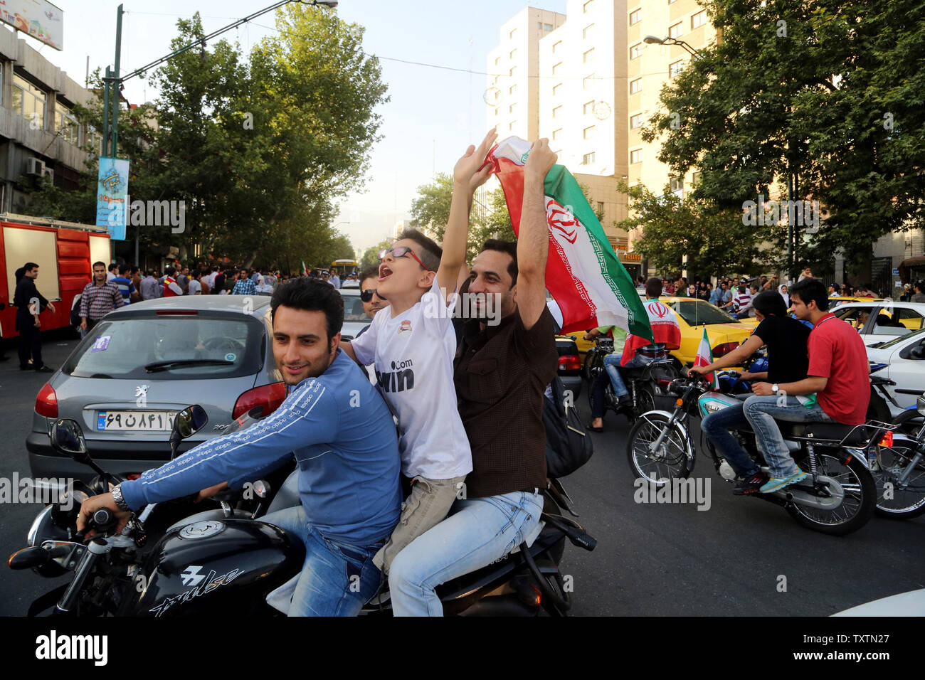 Iranian soccer fans flash the victory sign during a street celebration ...