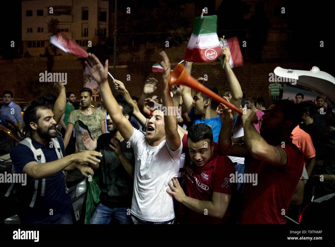 Soccer fans hold Iranian flags as they dance on streets of Tehran, Iran ...